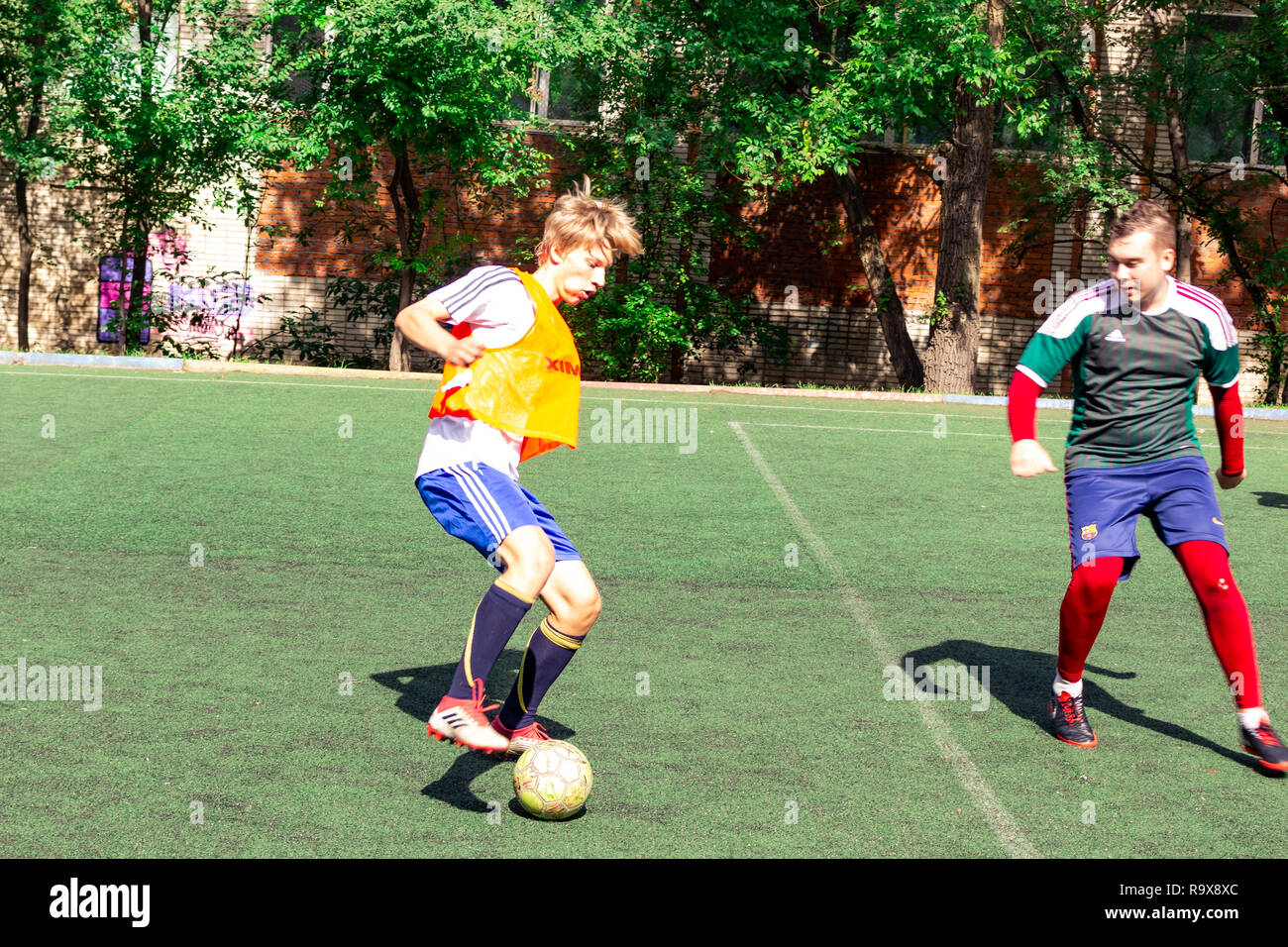 Young people play football on the green grass Stock Photo - Alamy