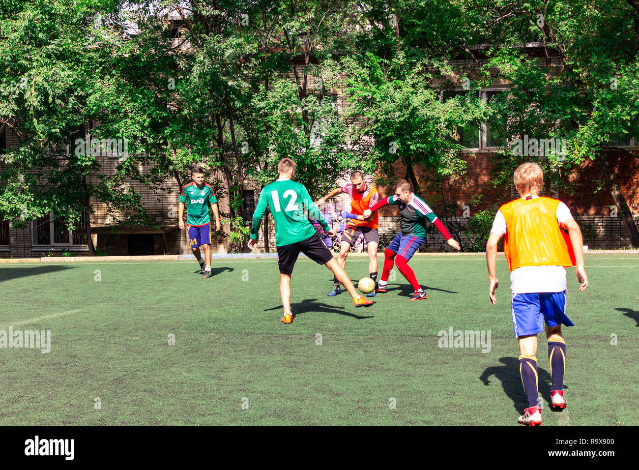 Young people play football on the green grass Stock Photo - Alamy