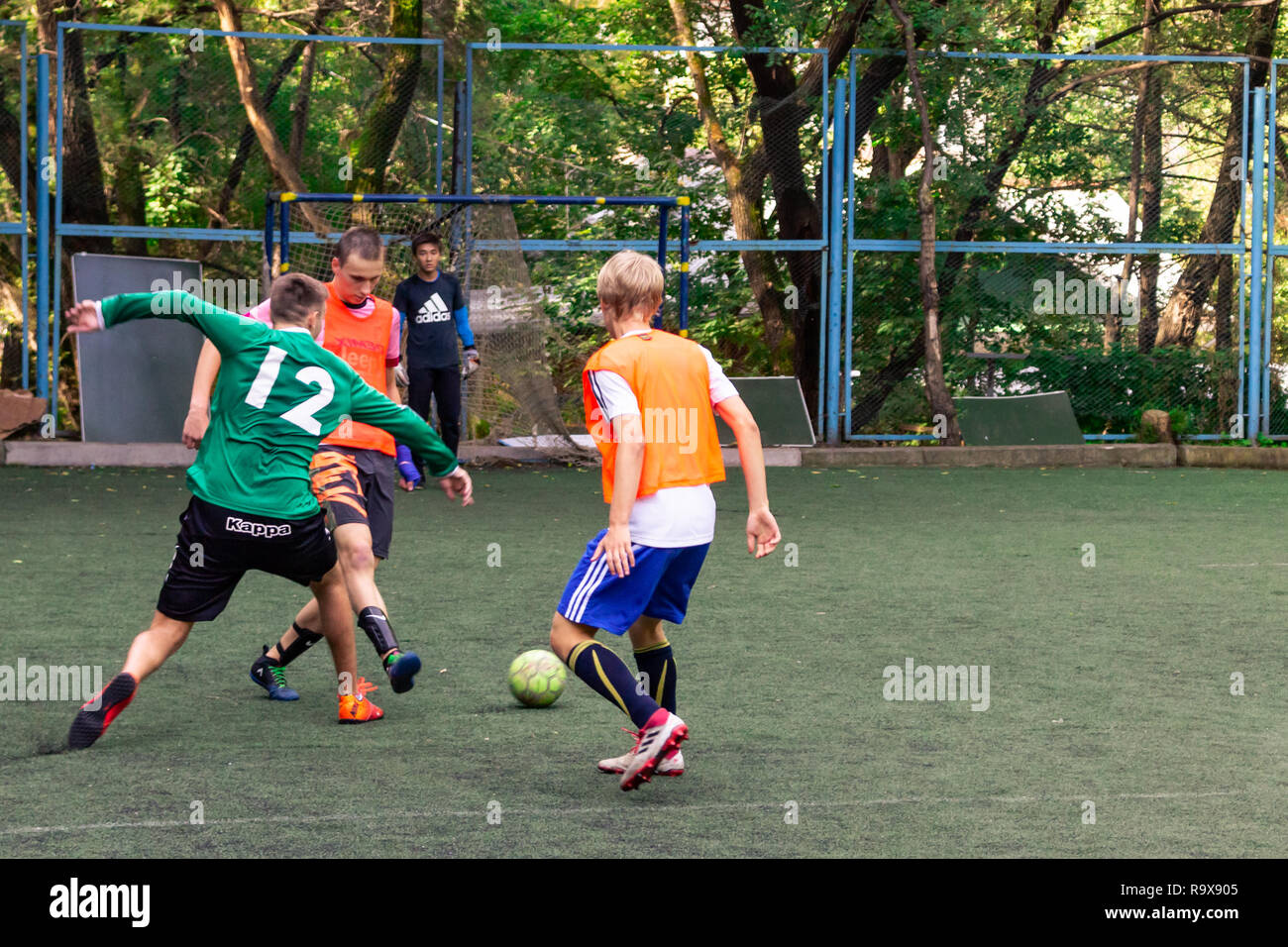 Young people play football on the green grass Stock Photo - Alamy