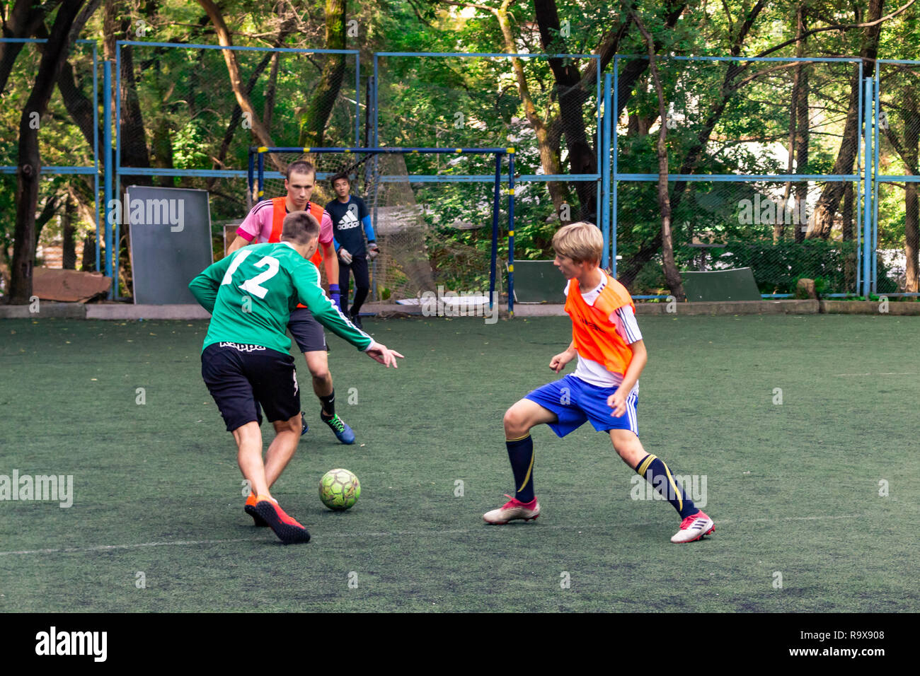 Young people play football on the green grass Stock Photo - Alamy