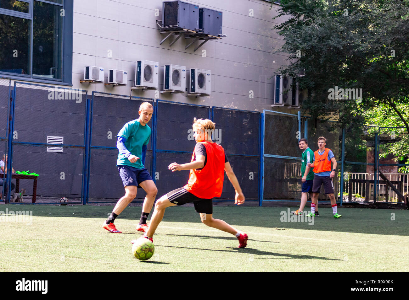 Young people play football on the green grass Stock Photo - Alamy