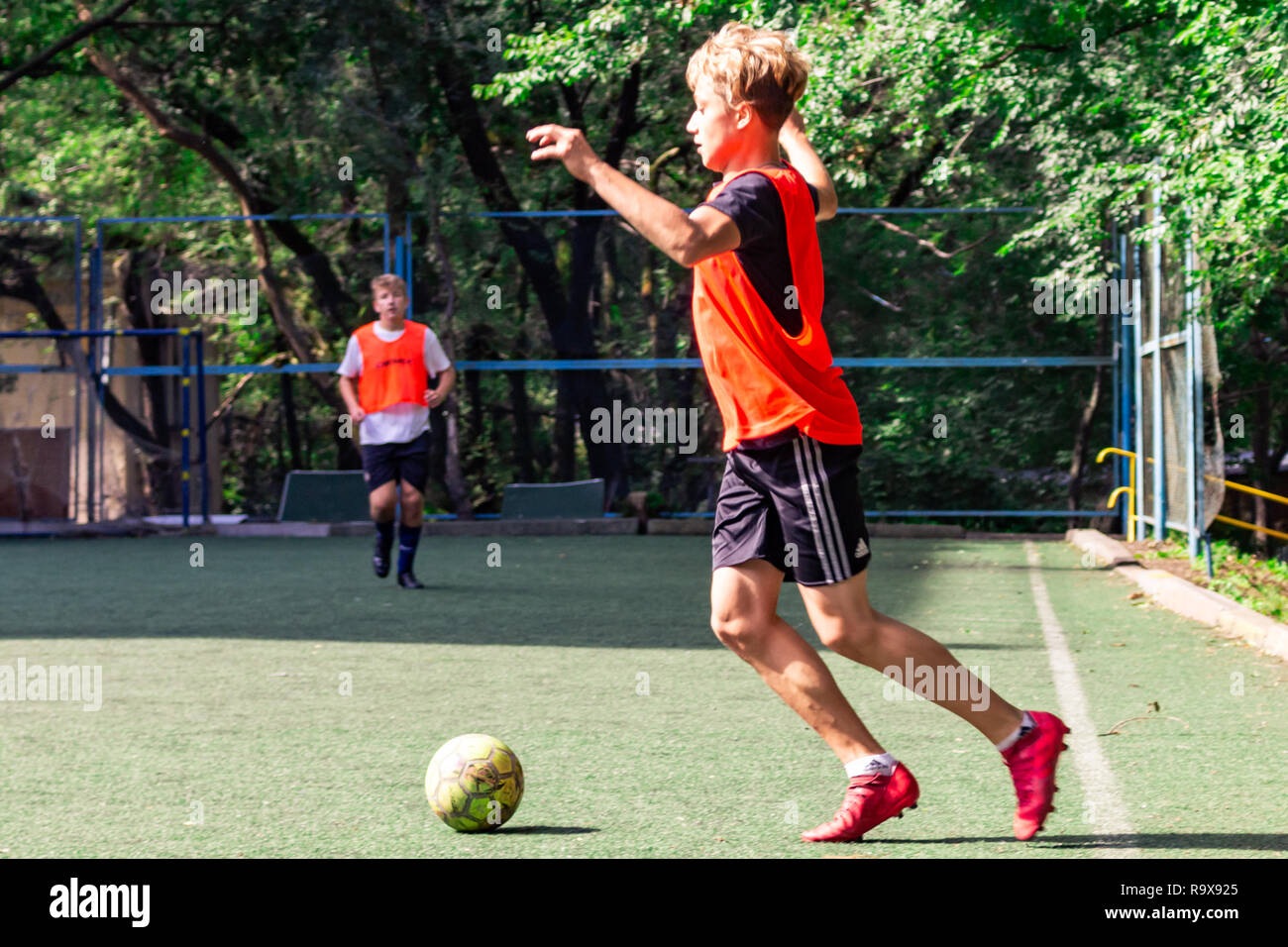 Young people play football on the green grass Stock Photo - Alamy