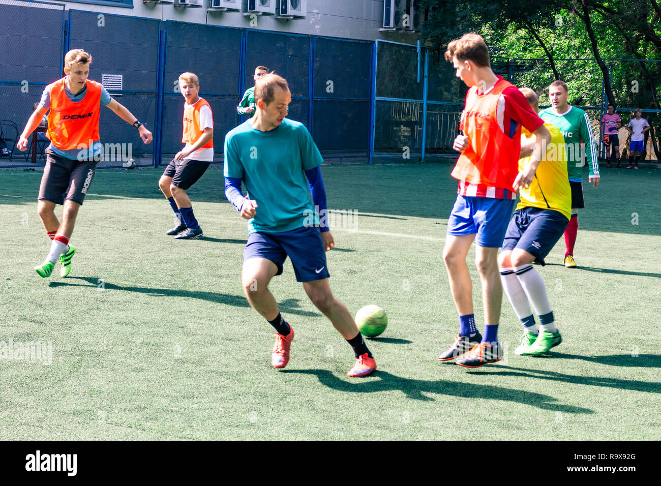 Young people play football on the green grass Stock Photo - Alamy