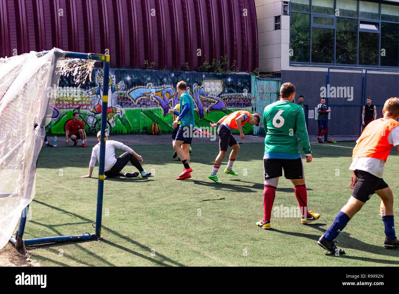 Young people play football on the green grass Stock Photo - Alamy