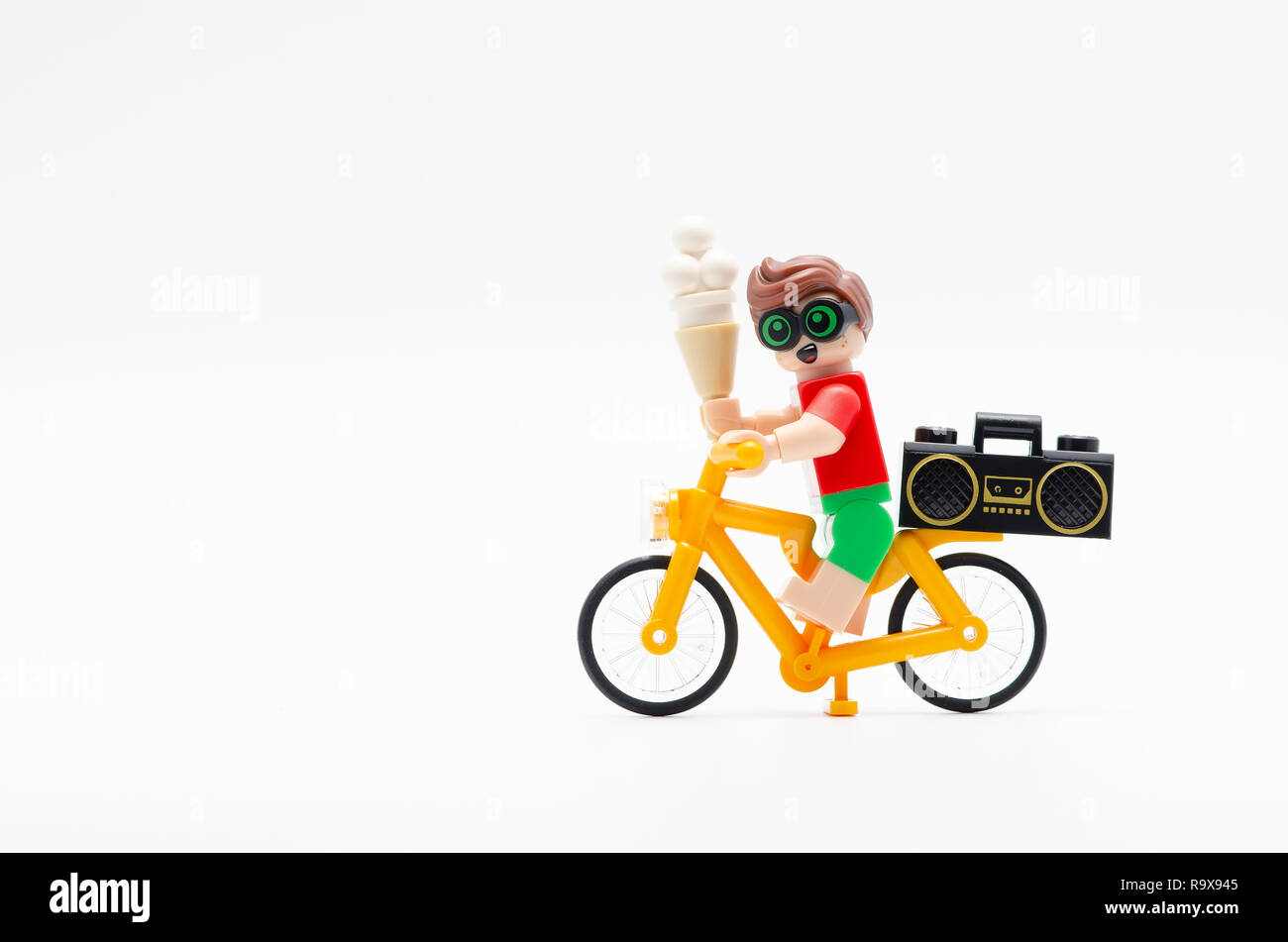lego robin riding bicycle with radio at his back and holding a ice ...