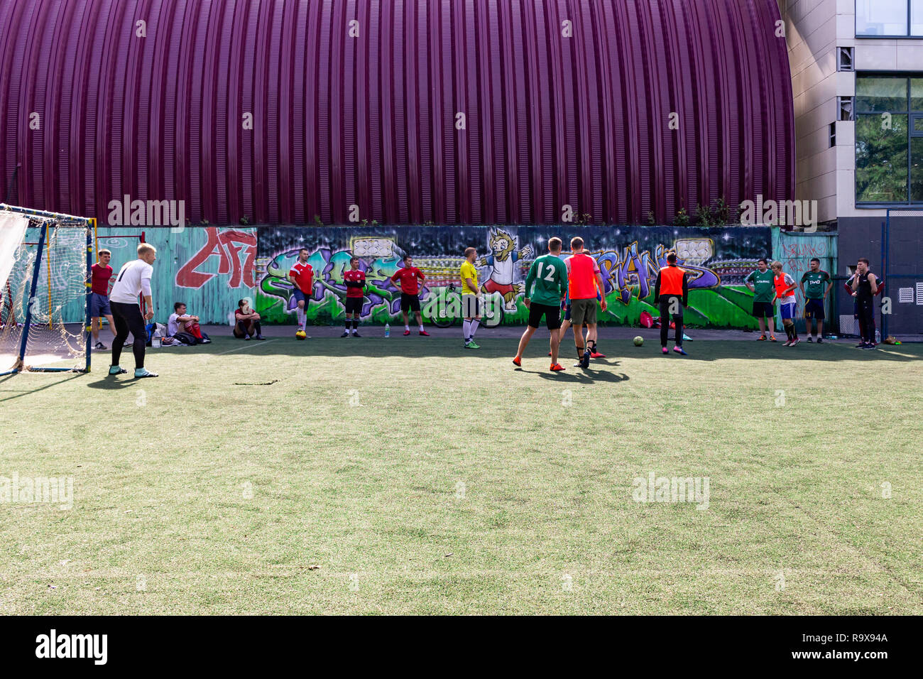 Young people play football on the green grass Stock Photo - Alamy
