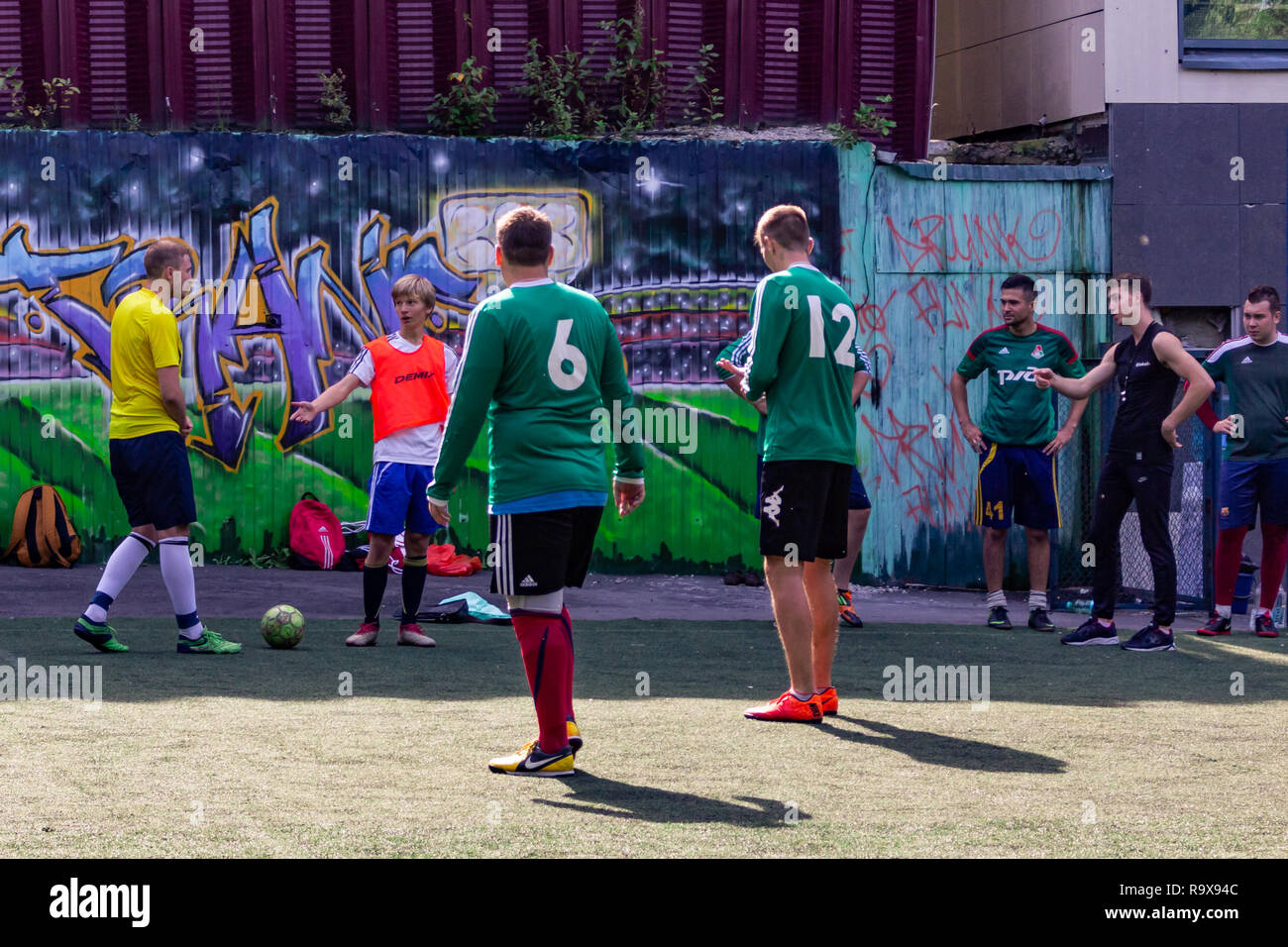 Young people play football on the green grass Stock Photo - Alamy