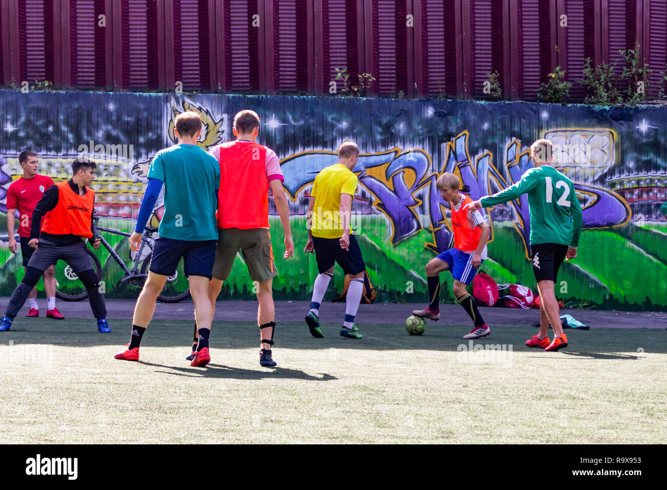 Young people play football on the green grass Stock Photo - Alamy