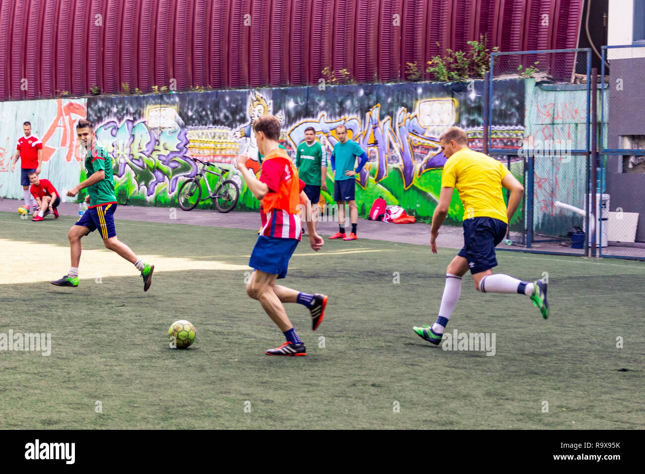 Young people play football on the green grass Stock Photo - Alamy