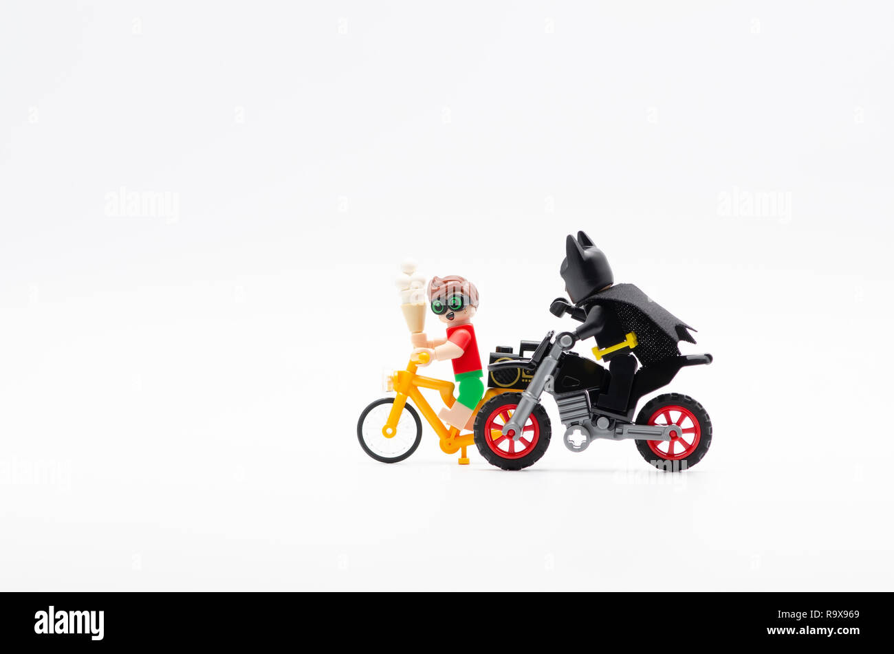 lego batman with robin riding bicycle with radio at his back and ...