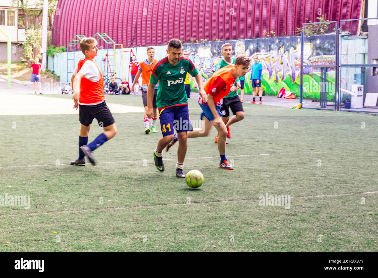 Young people play football on the green grass Stock Photo - Alamy