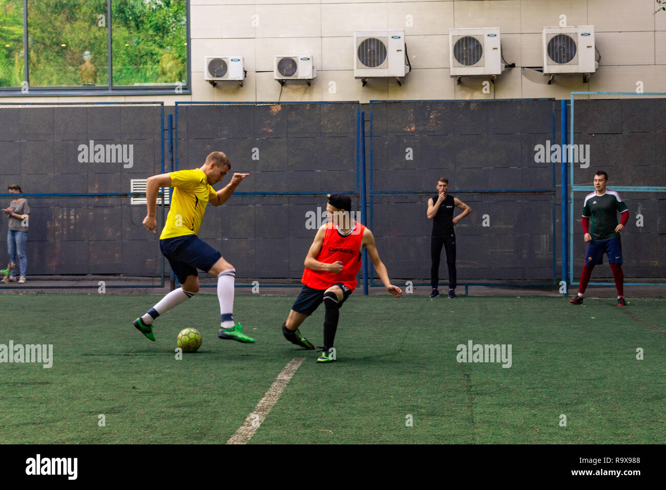Young people play football on the green grass Stock Photo - Alamy