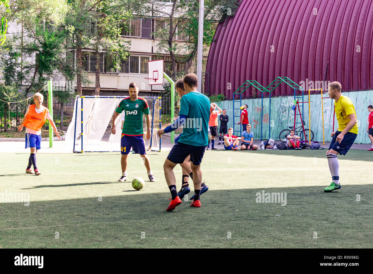 Young people play football on the green grass Stock Photo - Alamy