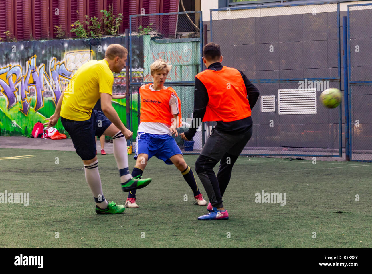 Young people play football on the green grass Stock Photo - Alamy