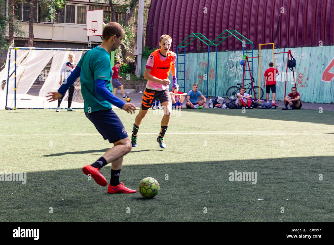 Young people play football on the green grass Stock Photo - Alamy