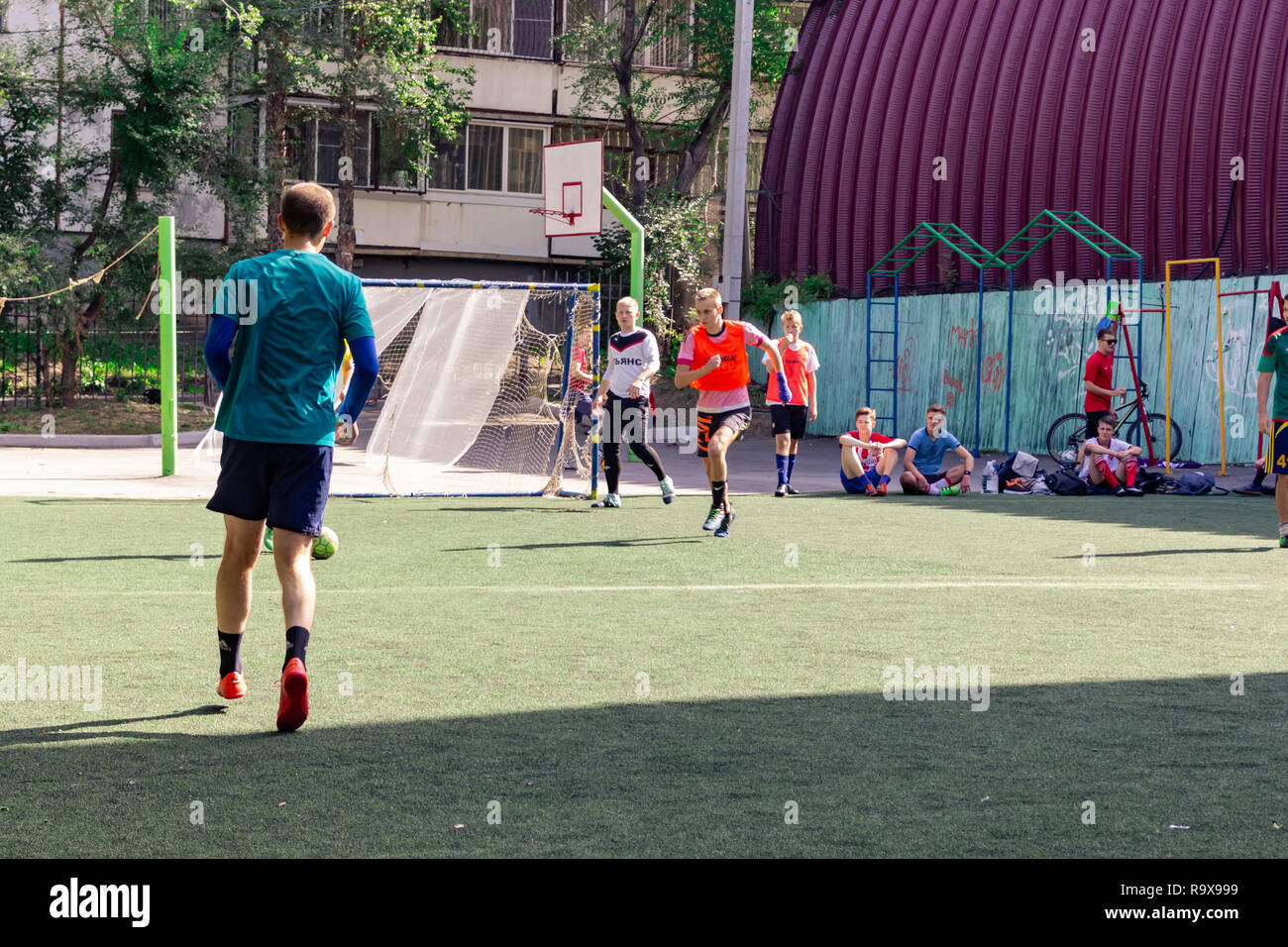 Young people play football on the green grass Stock Photo - Alamy