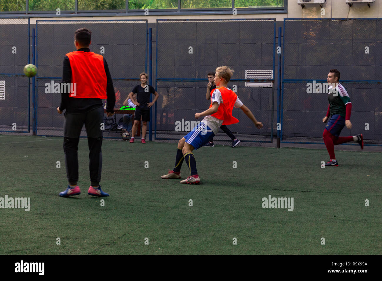 Young people play football on the green grass Stock Photo - Alamy