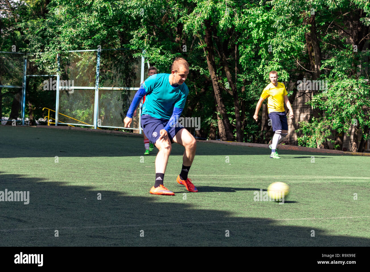 Young people play football on the green grass Stock Photo - Alamy