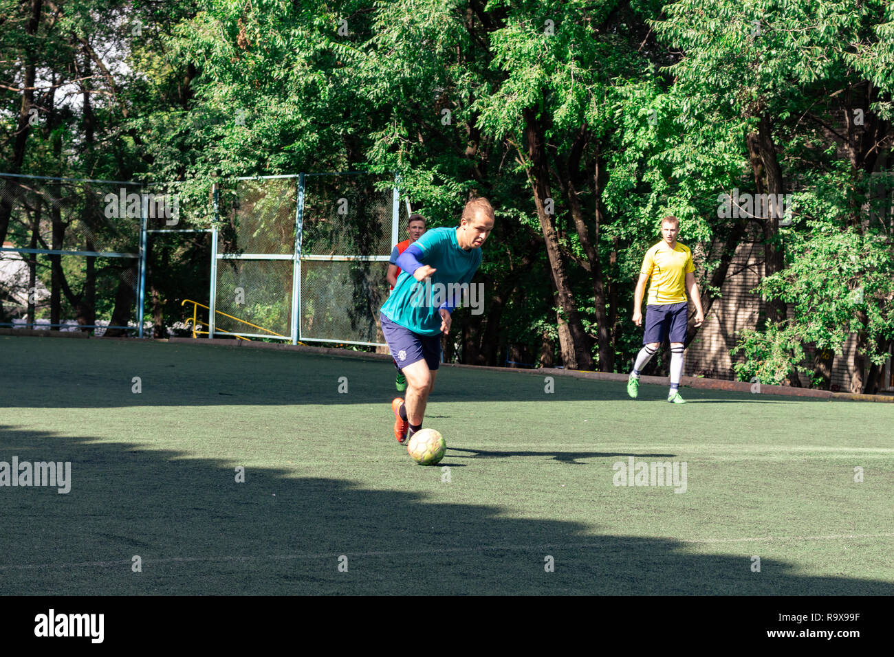 Young people play football on the green grass Stock Photo - Alamy
