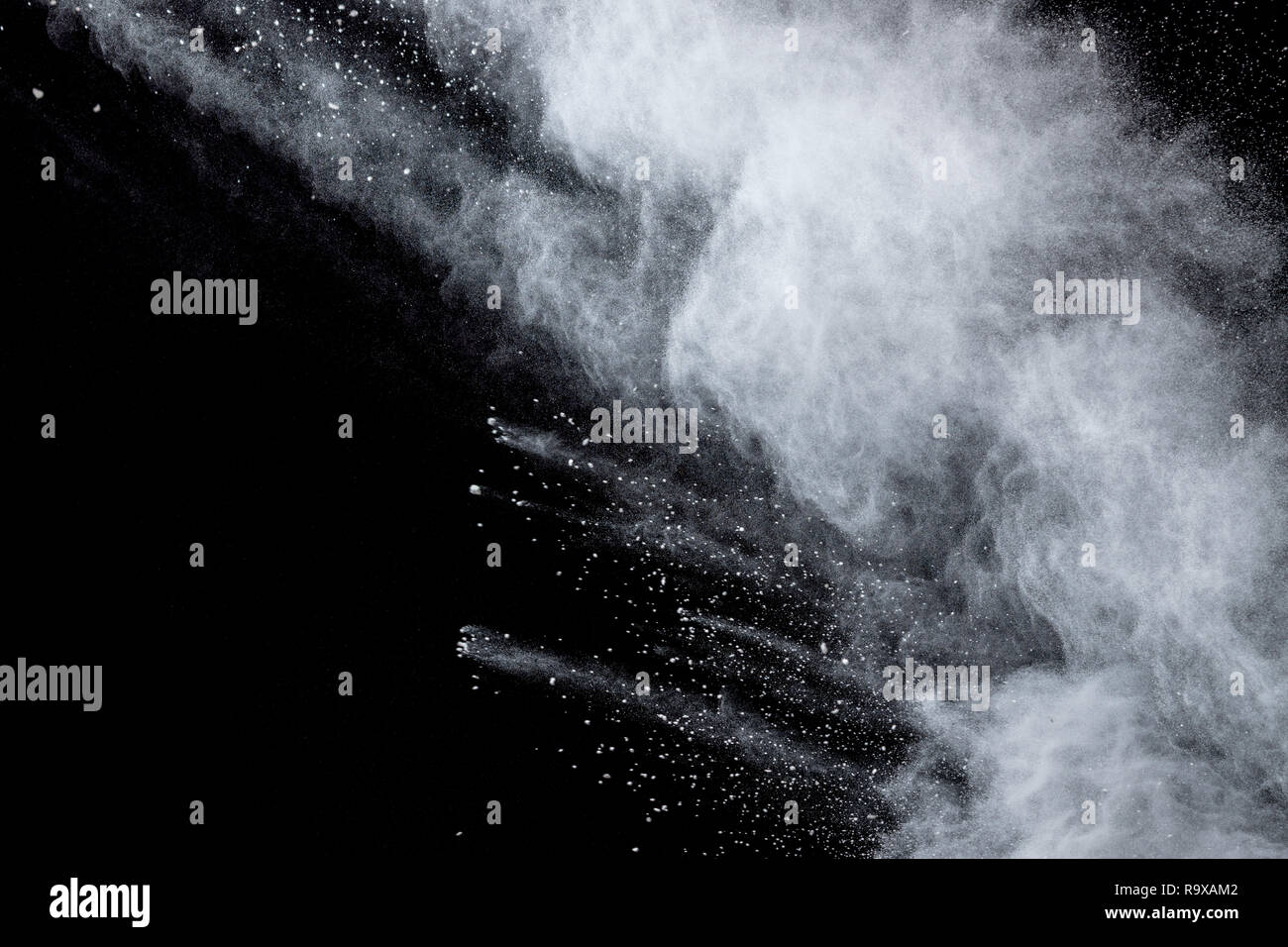 Bizarre forms of white powder explosion cloud against dark background ...