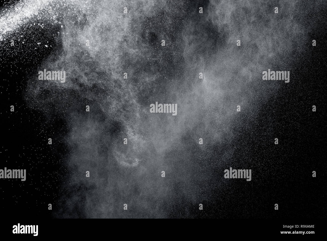 Bizarre forms of white powder explosion cloud against dark background ...