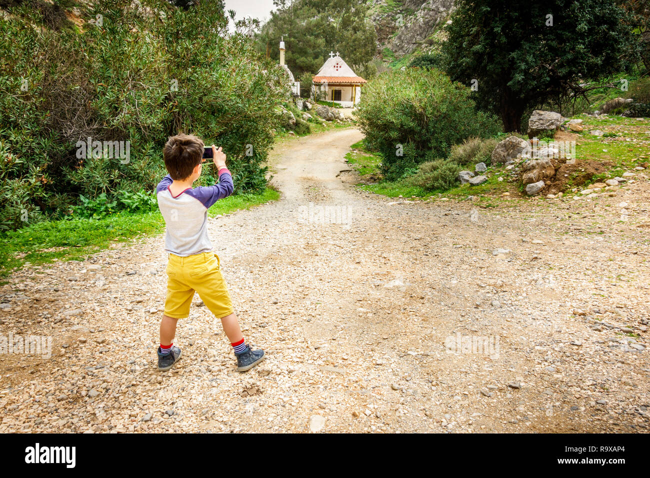 Rear view of boy photographing church Crete Greece Stock Photo - Alamy