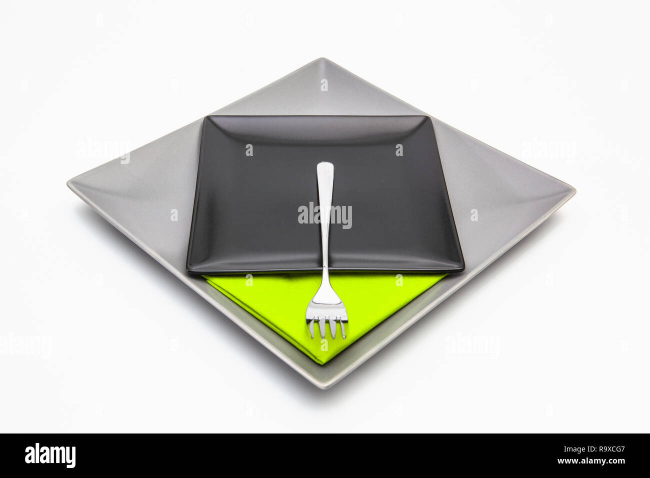 Black and gray square plates on the white wooden table.Top view.Flat ...