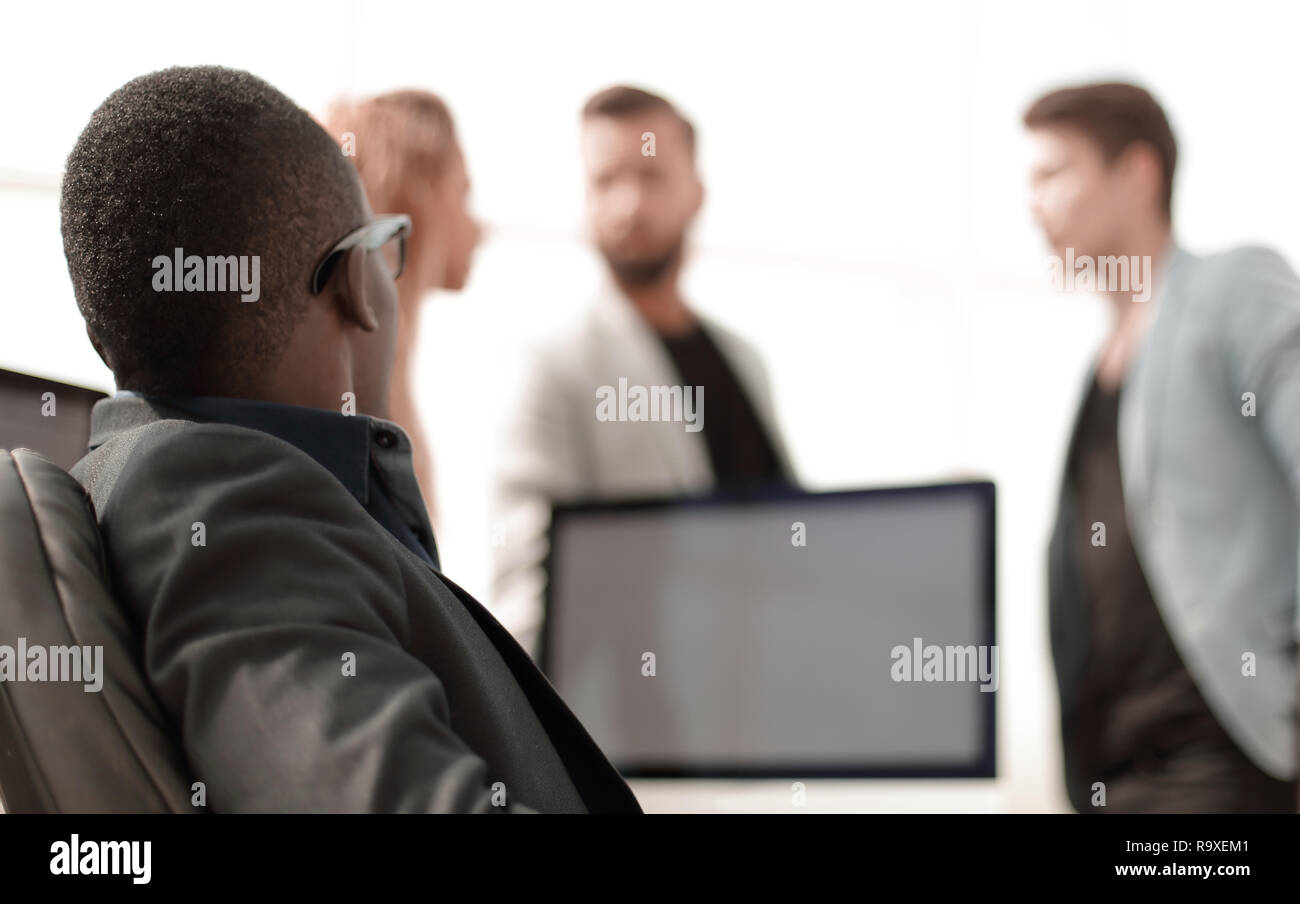 rear view.businessman sitting at his Desk Stock Photo - Alamy