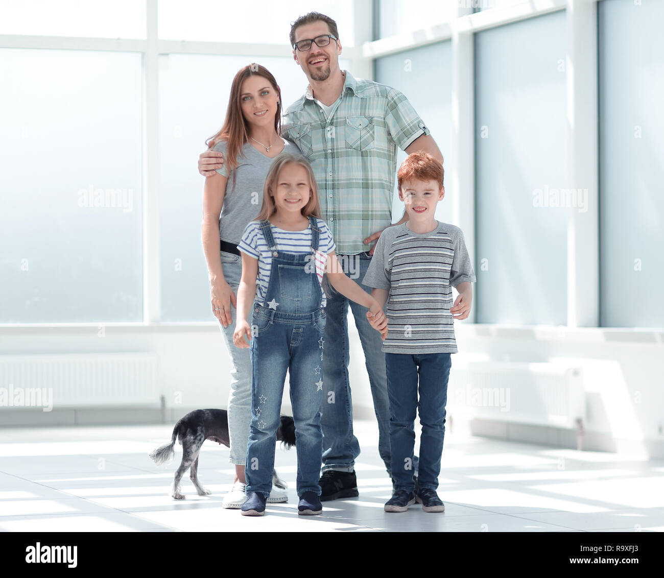 family with two children standing in a new house Stock Photo - Alamy