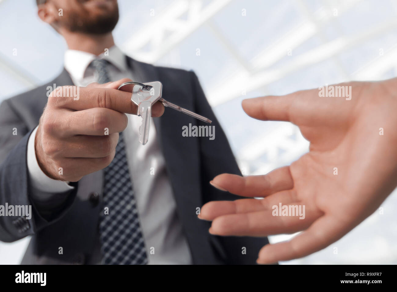 Cropped image of estate agent giving house keys to man in office Stock ...