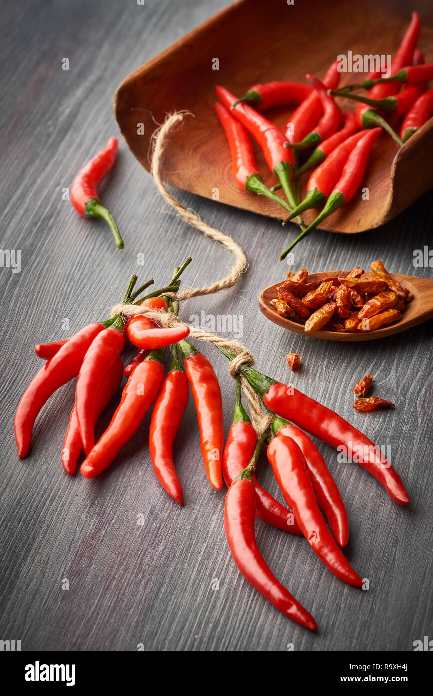 Closeup on red hot chili peppers tied with a string and a spoon with ...