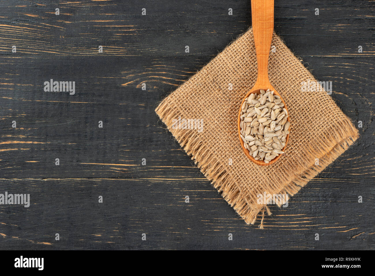 Sunflower seeds without shell in a spoon on the burlap and table, top ...