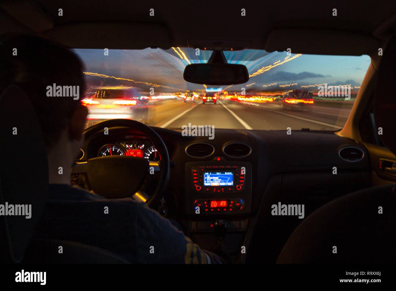 Night road view from inside a car with street lights and motion blurred ...