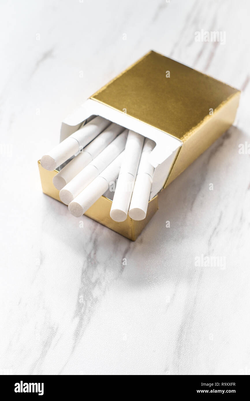 Open half empty gold pack of cigarettes on marble kitchen table Stock ...