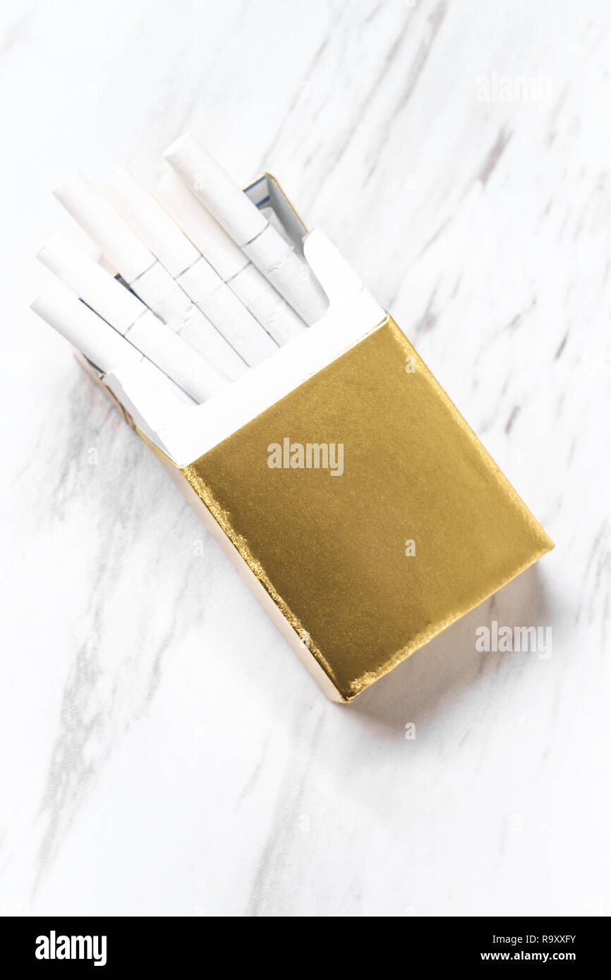 Open half empty gold pack of cigarettes on marble kitchen table Stock ...
