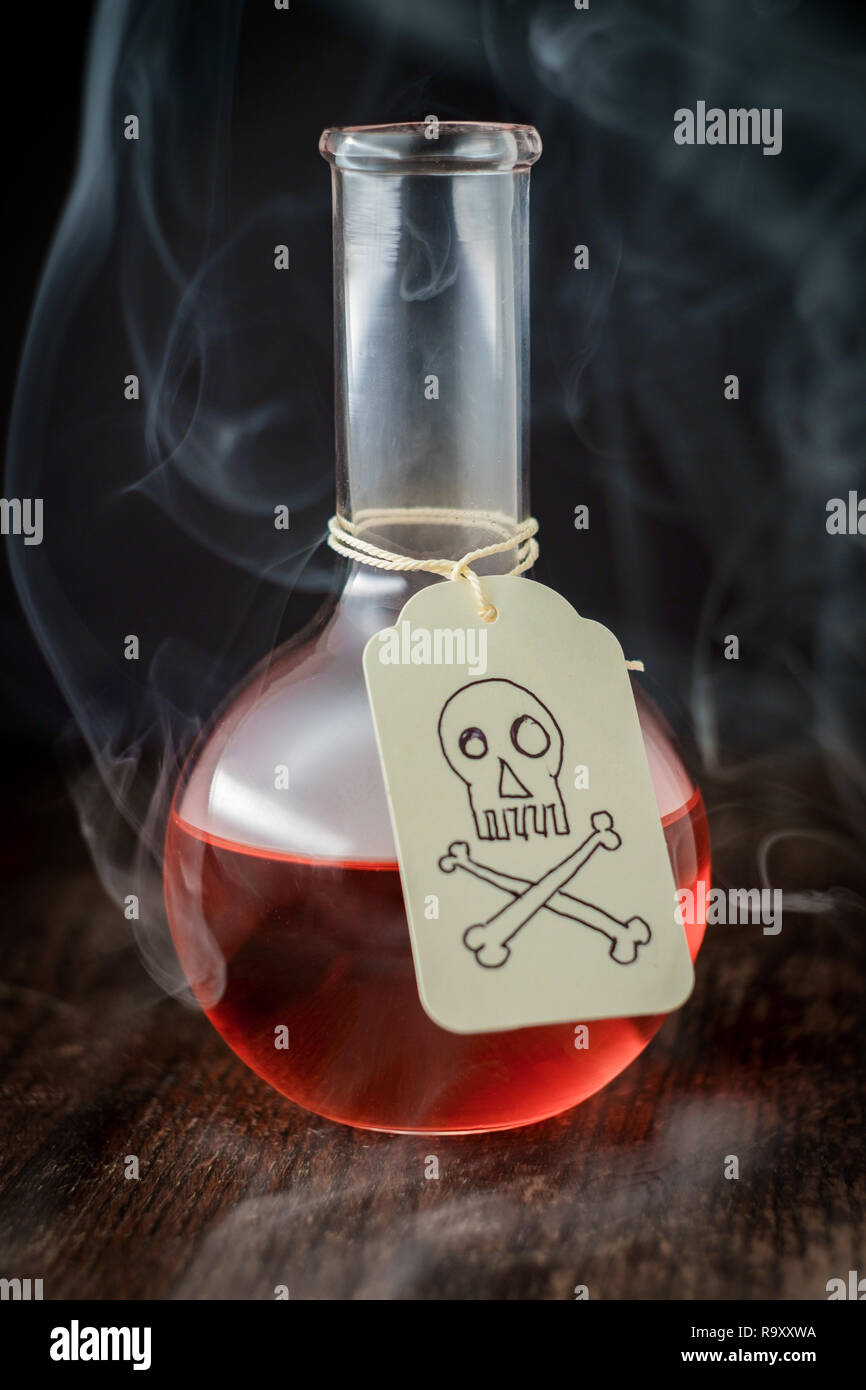 Skull and crossbones paper tag labels bottle of poison Stock Photo - Alamy