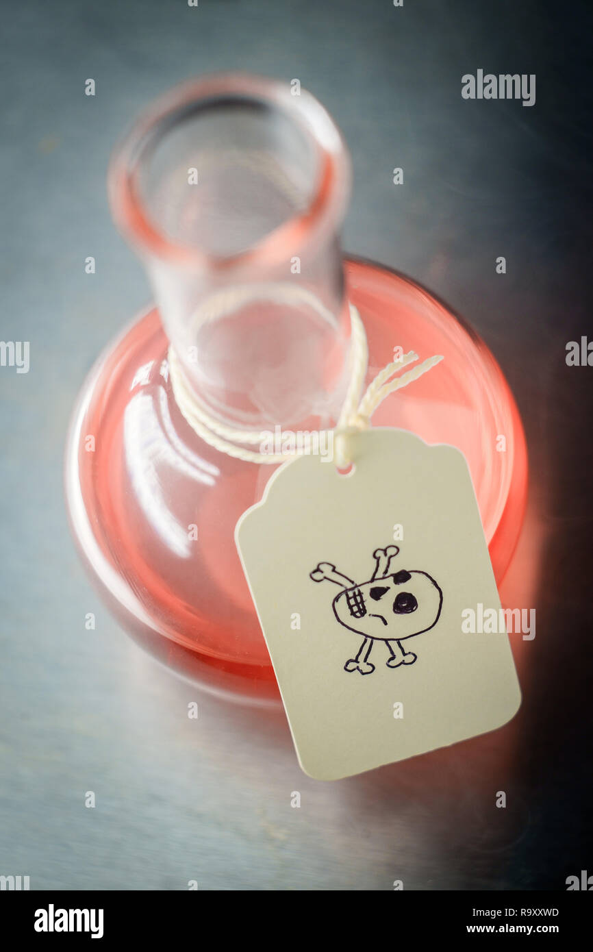 Skull and crossbones paper tag labels bottle of poison Stock Photo - Alamy