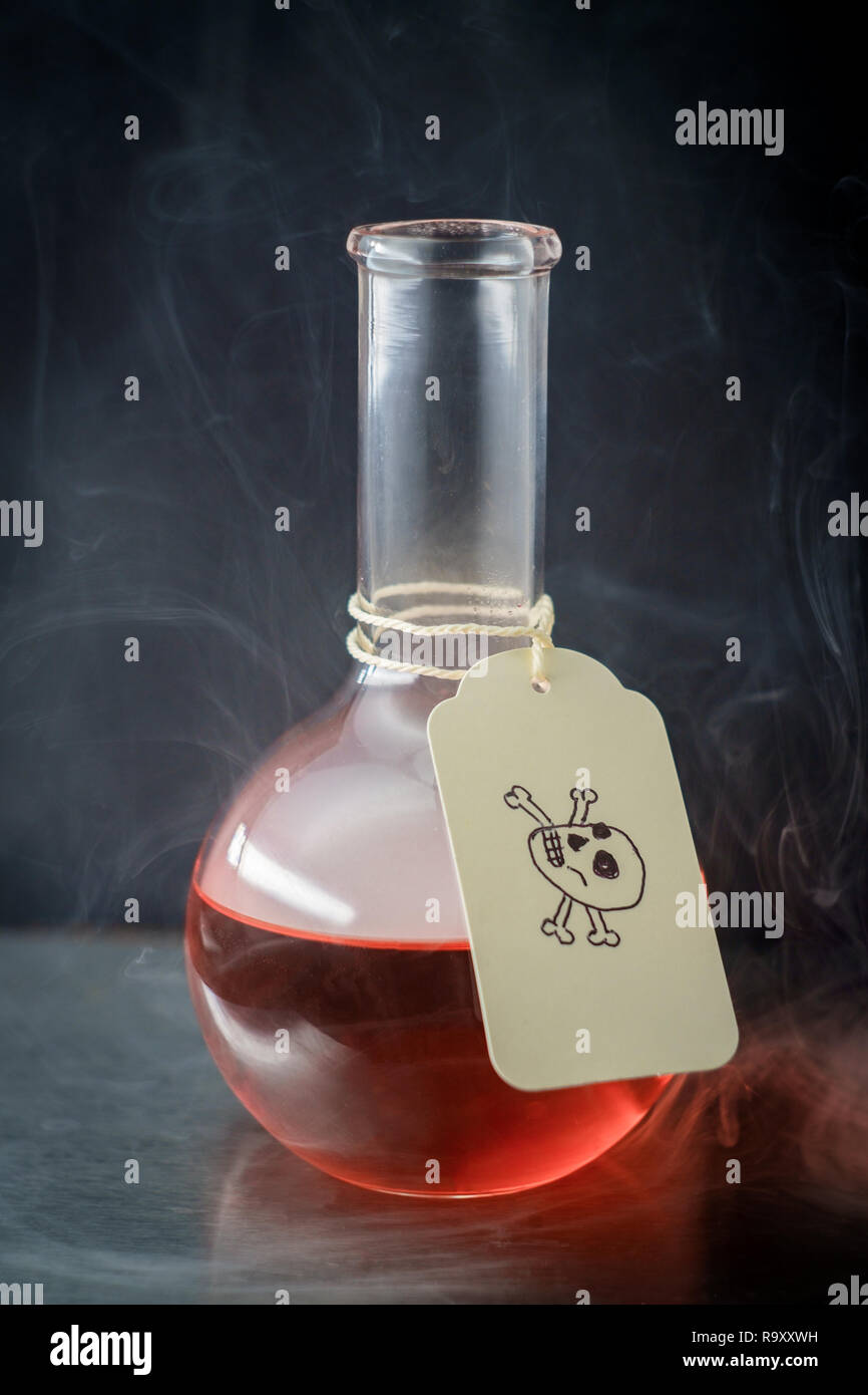 Skull and crossbones paper tag labels bottle of poison Stock Photo - Alamy