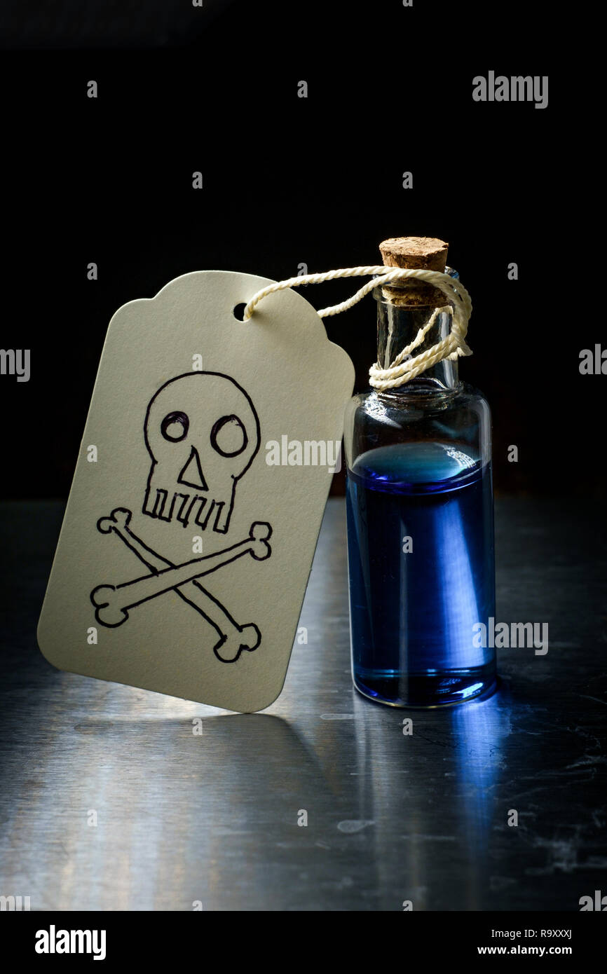 Skull and crossbones paper tag labels bottle of poison Stock Photo - Alamy