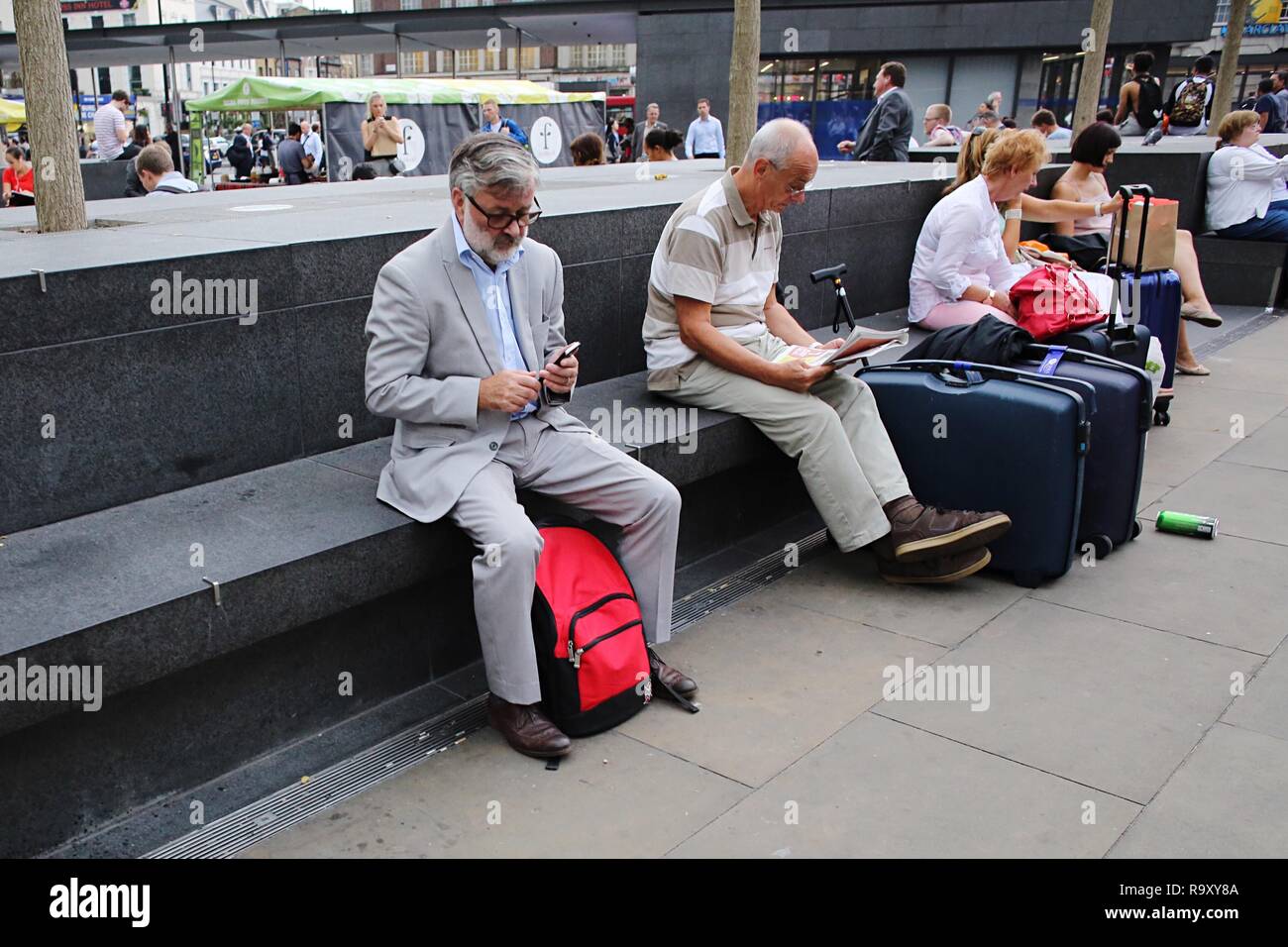 people are sitting on a bench in London Stock Photo - Alamy