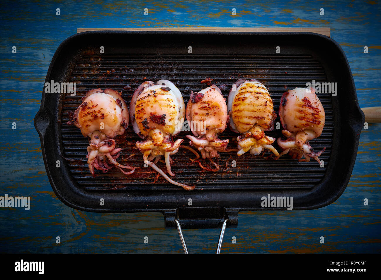Grilled cuttlefish squid in cast iron grill on wood Stock Photo - Alamy