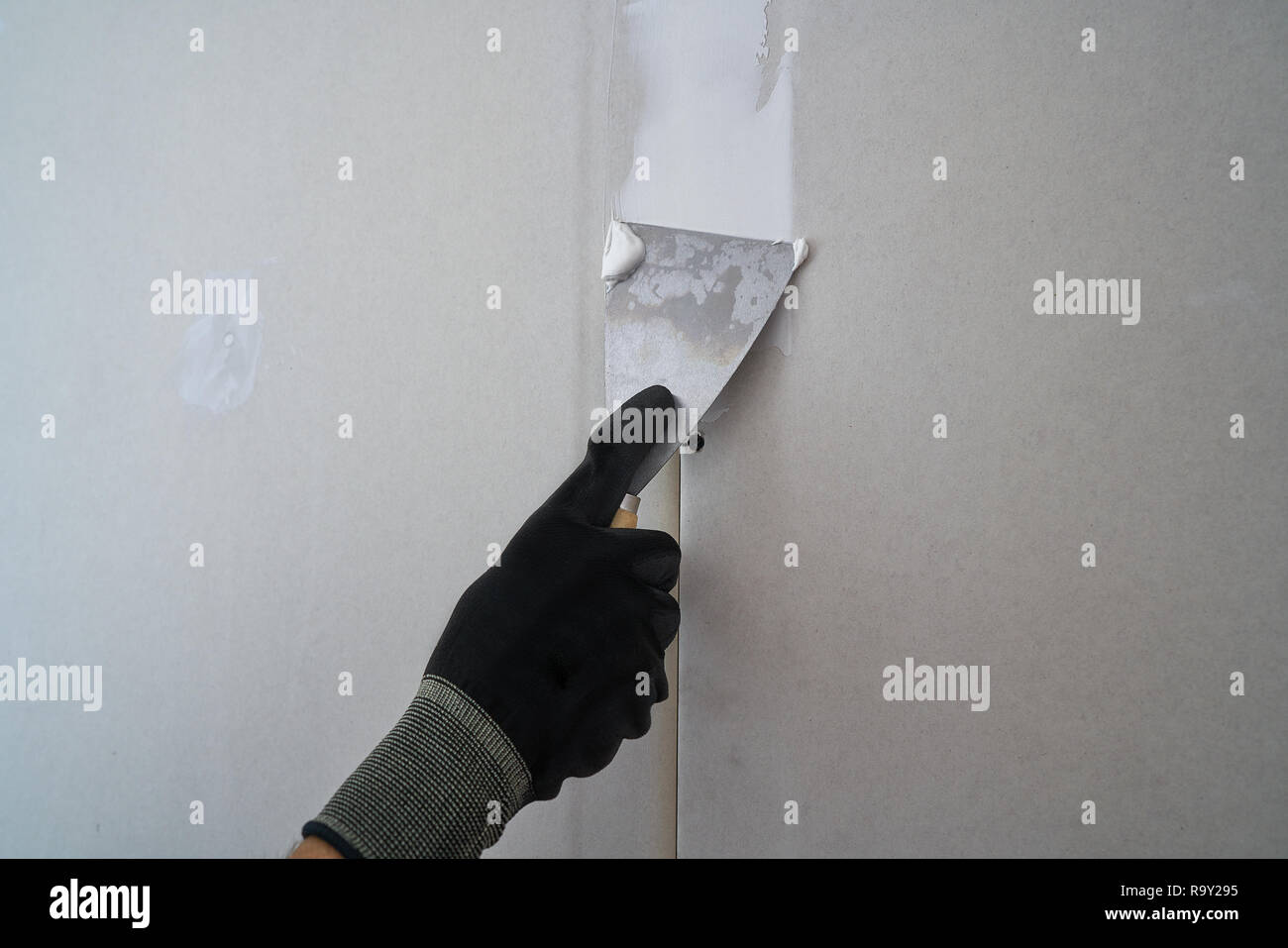 laminated plasterboard plastering join detail spatula and hand Stock ...