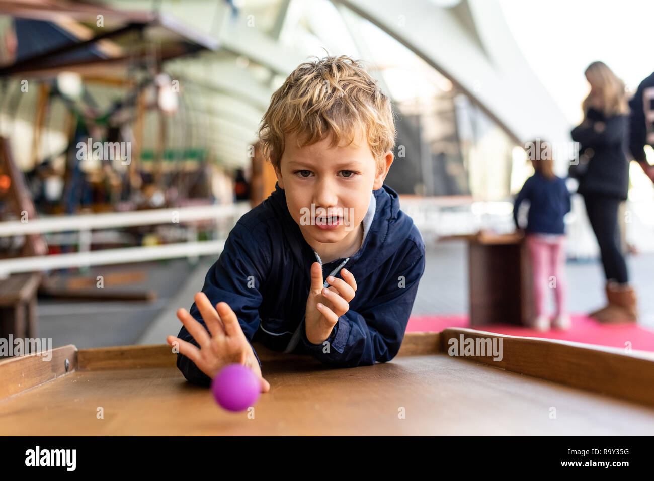 Child concentrated while playing with a medieval ball game Stock Photo ...