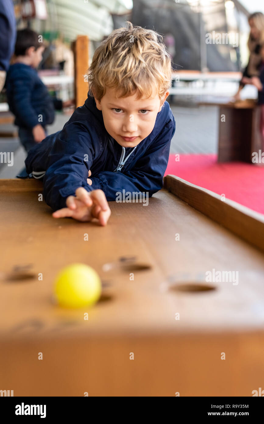 Child concentrated while playing with a medieval ball game Stock Photo ...