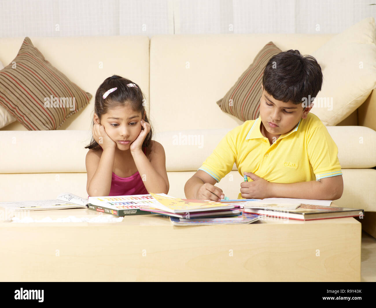 YOUNG BOY AND GIRL DRAWING AND STUDYING IN THEIR HOME Stock Photo - Alamy