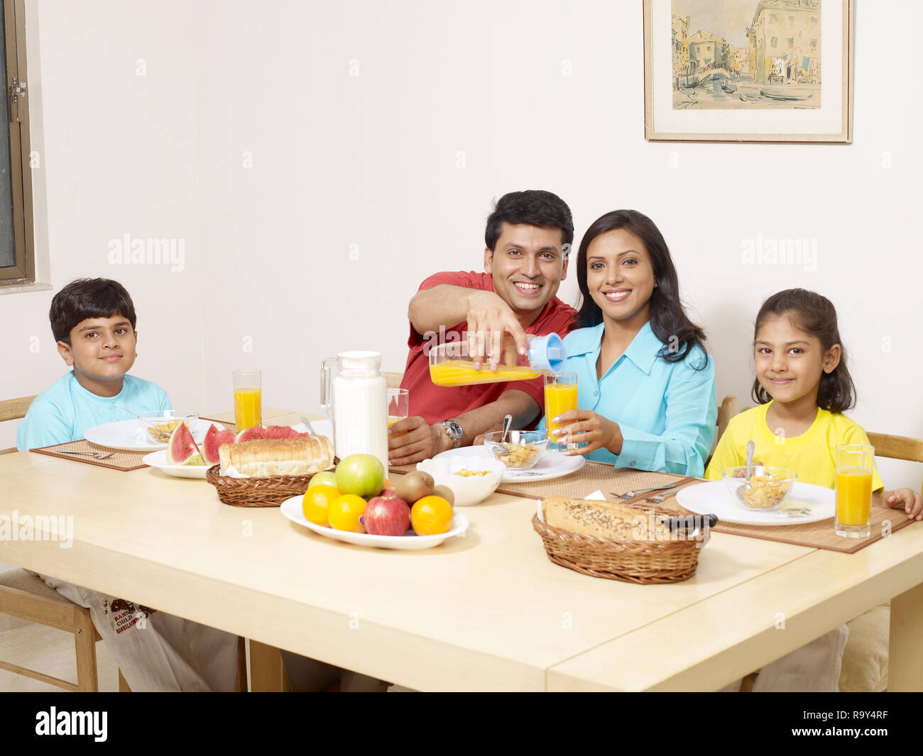 FAMILY OF FOUR eating breakfast Stock Photo - Alamy
