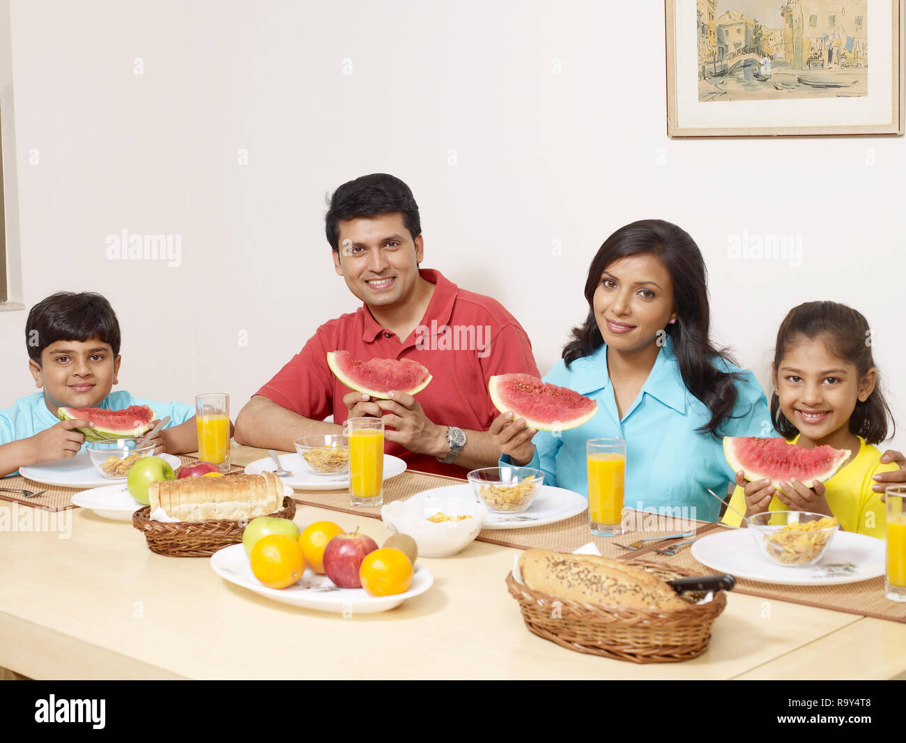 FAMILY OF FOUR eating breakfast Stock Photo - Alamy