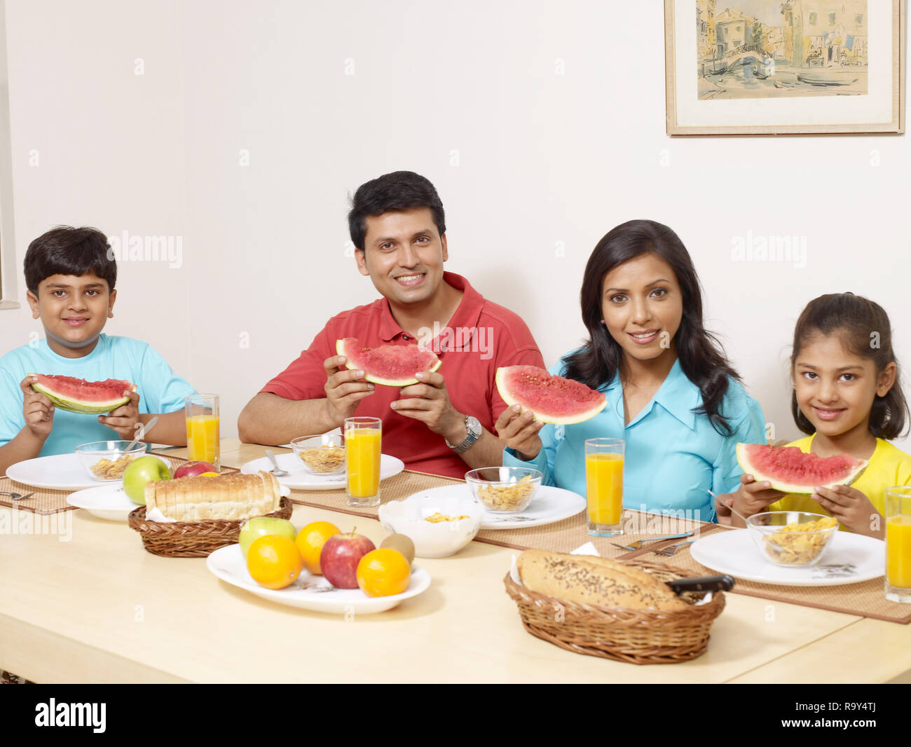 FAMILY OF FOUR eating breakfast Stock Photo - Alamy