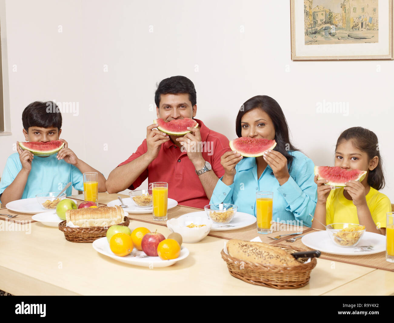 FAMILY OF FOUR eating breakfast Stock Photo - Alamy