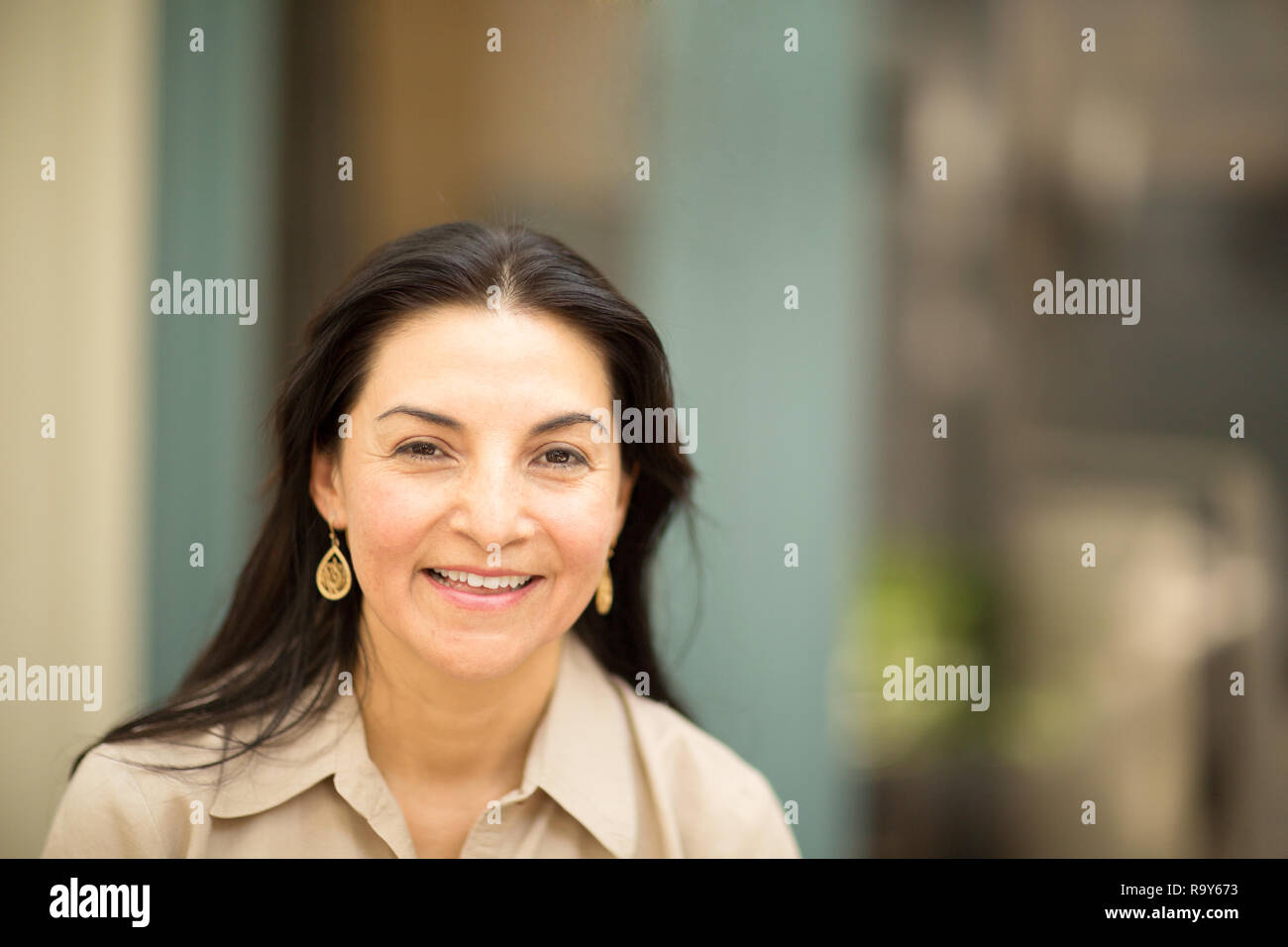 Happy Hispanic woman smiling and standing outside Stock Photo - Alamy